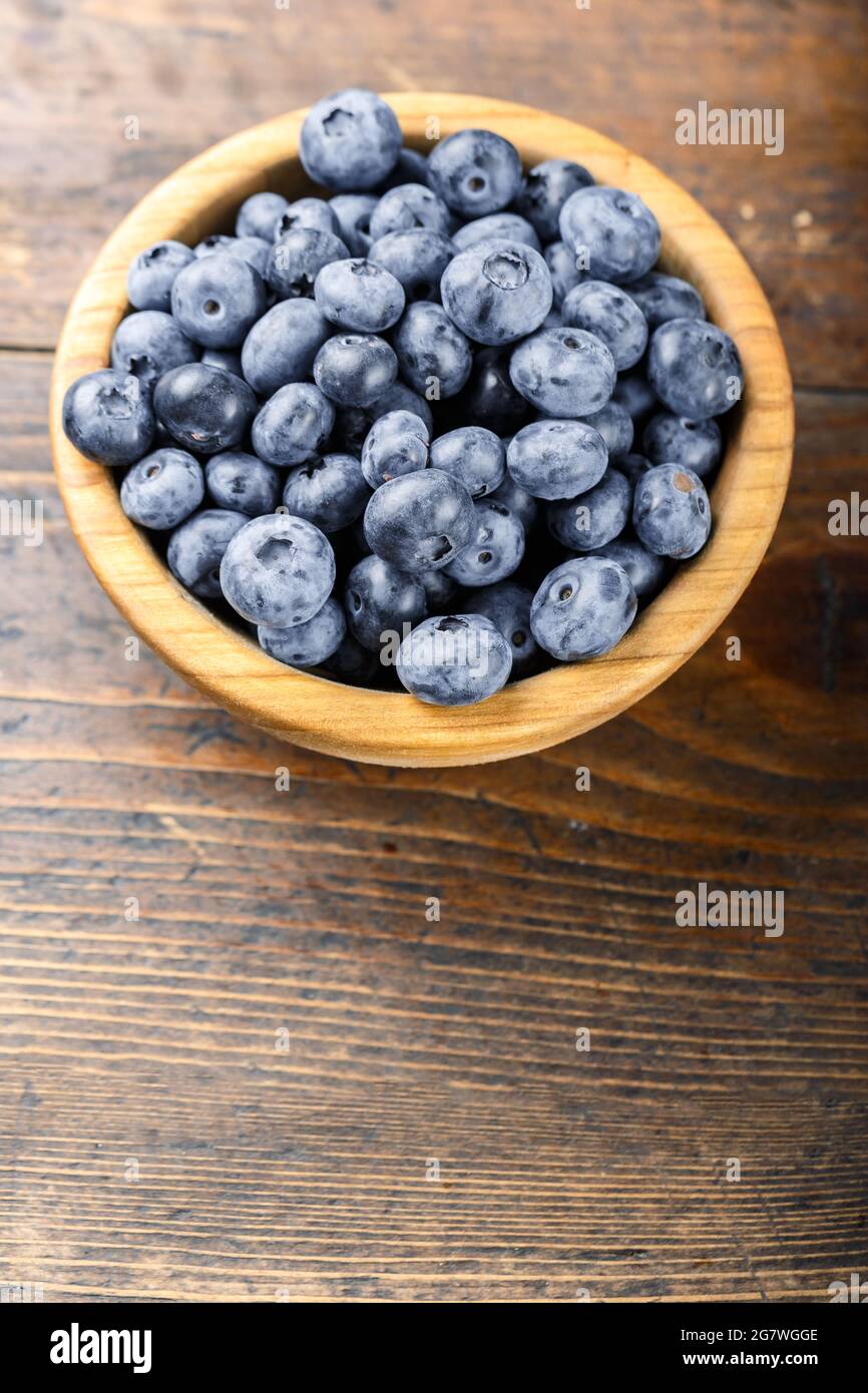 Fresh blueberries in a wooden bowl. Healthy and dietary food concept ...