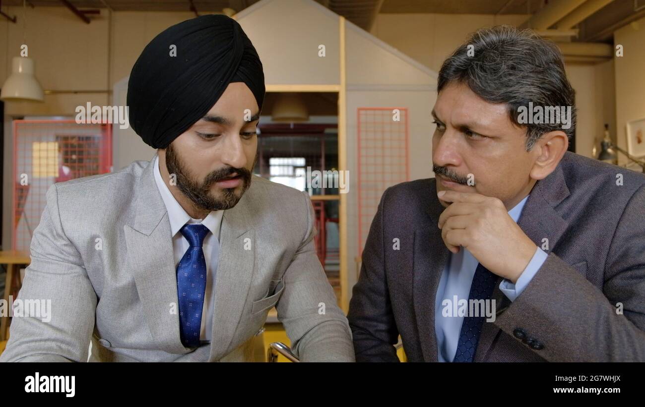 Sikh businessman from India wearing the black turban having a meeting ...