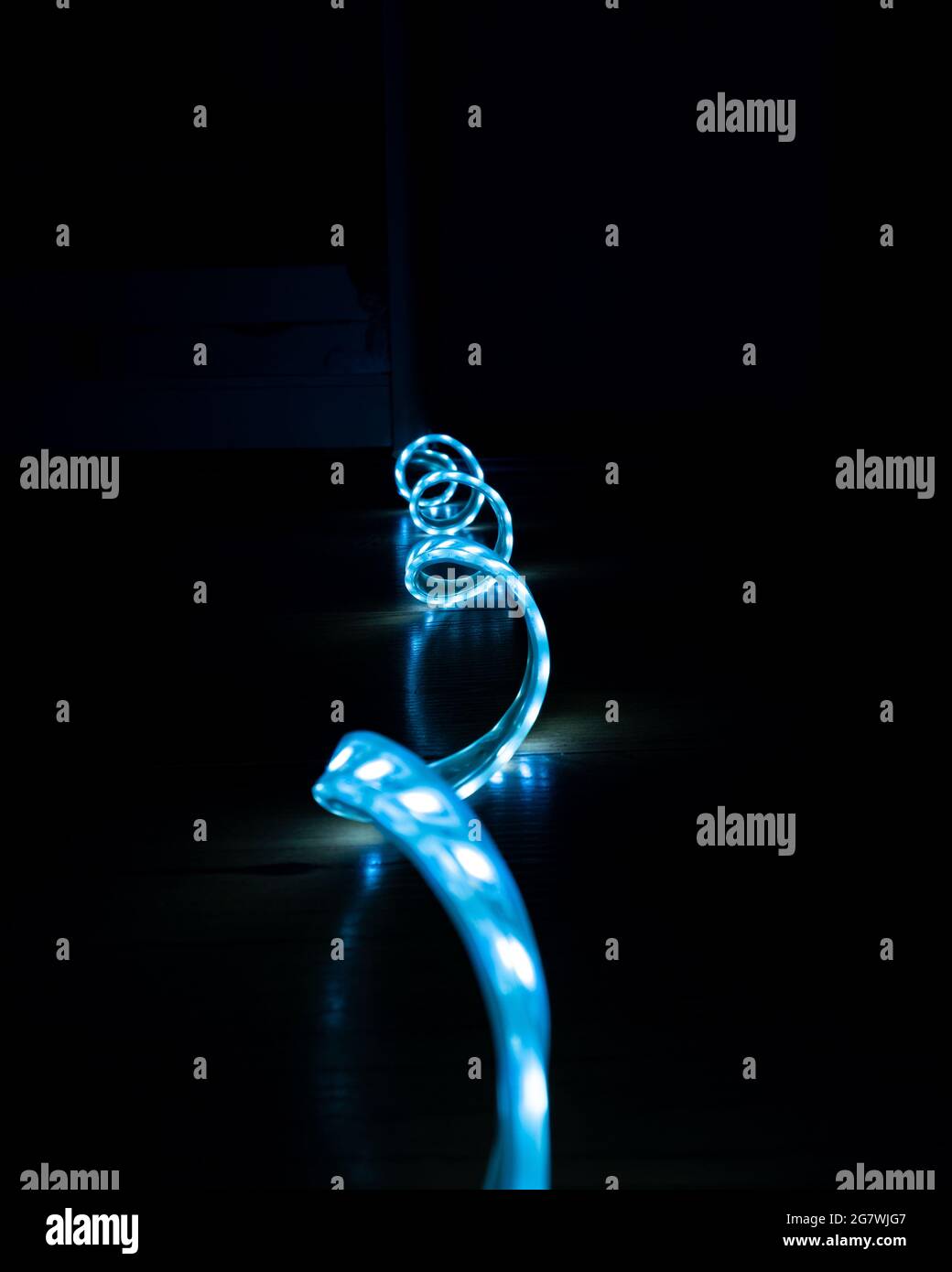 blue glowing LED strip with cold light on a black background close-up ...