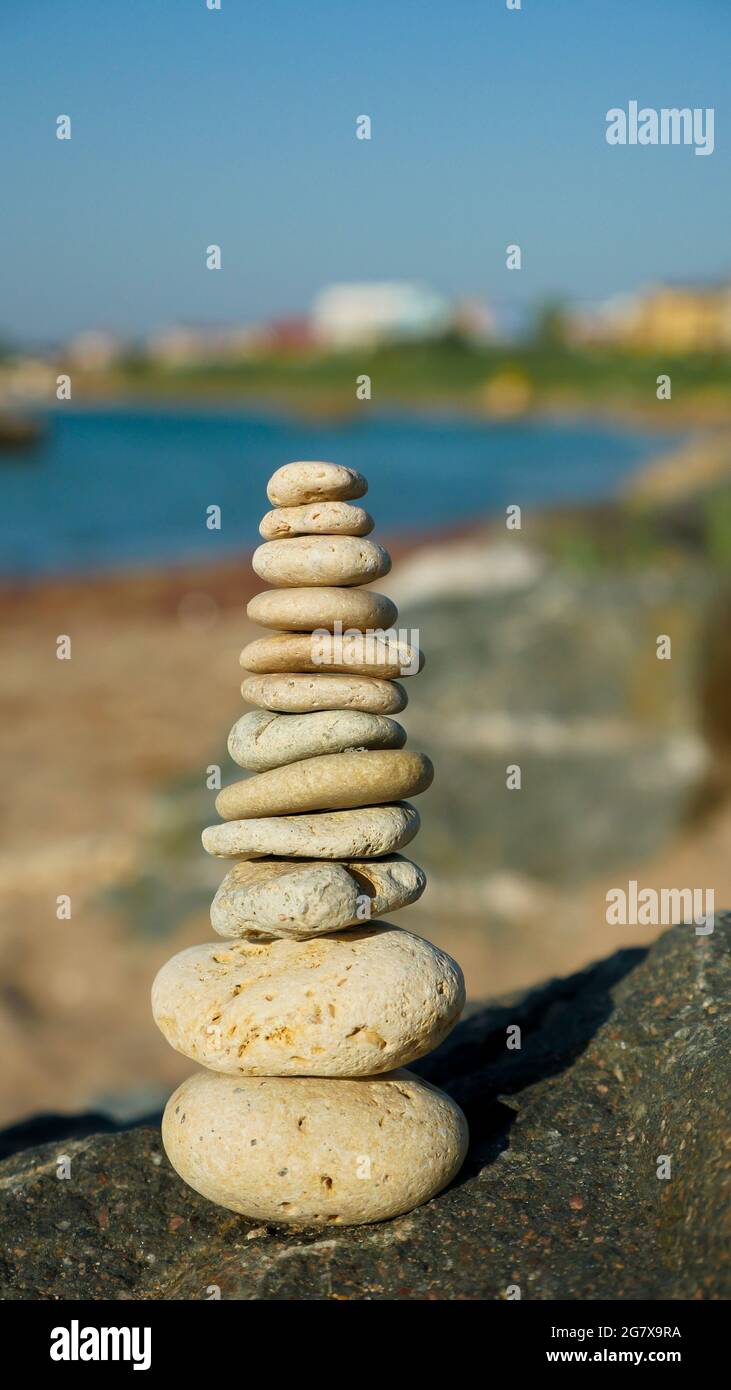 Stone pyramid on sea stone coast near to sand beach. Holidays vacation ...
