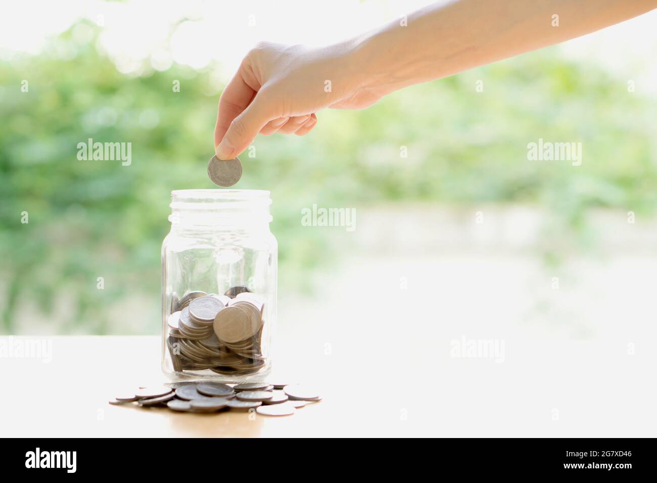 Hand dropping coins hi-res stock photography and images - Alamy