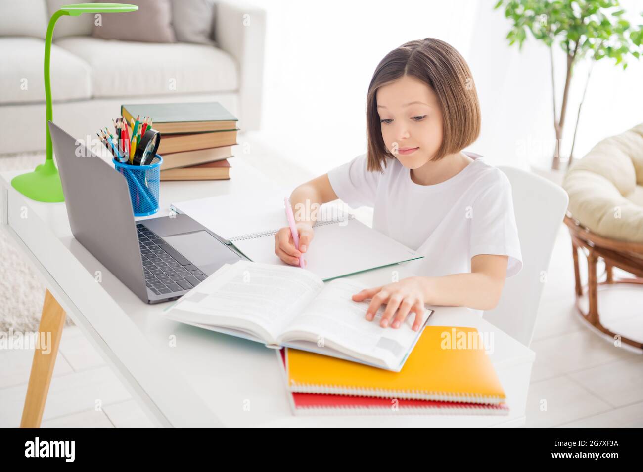 Photo portrait little girl writing homework in copybook reading book at ...