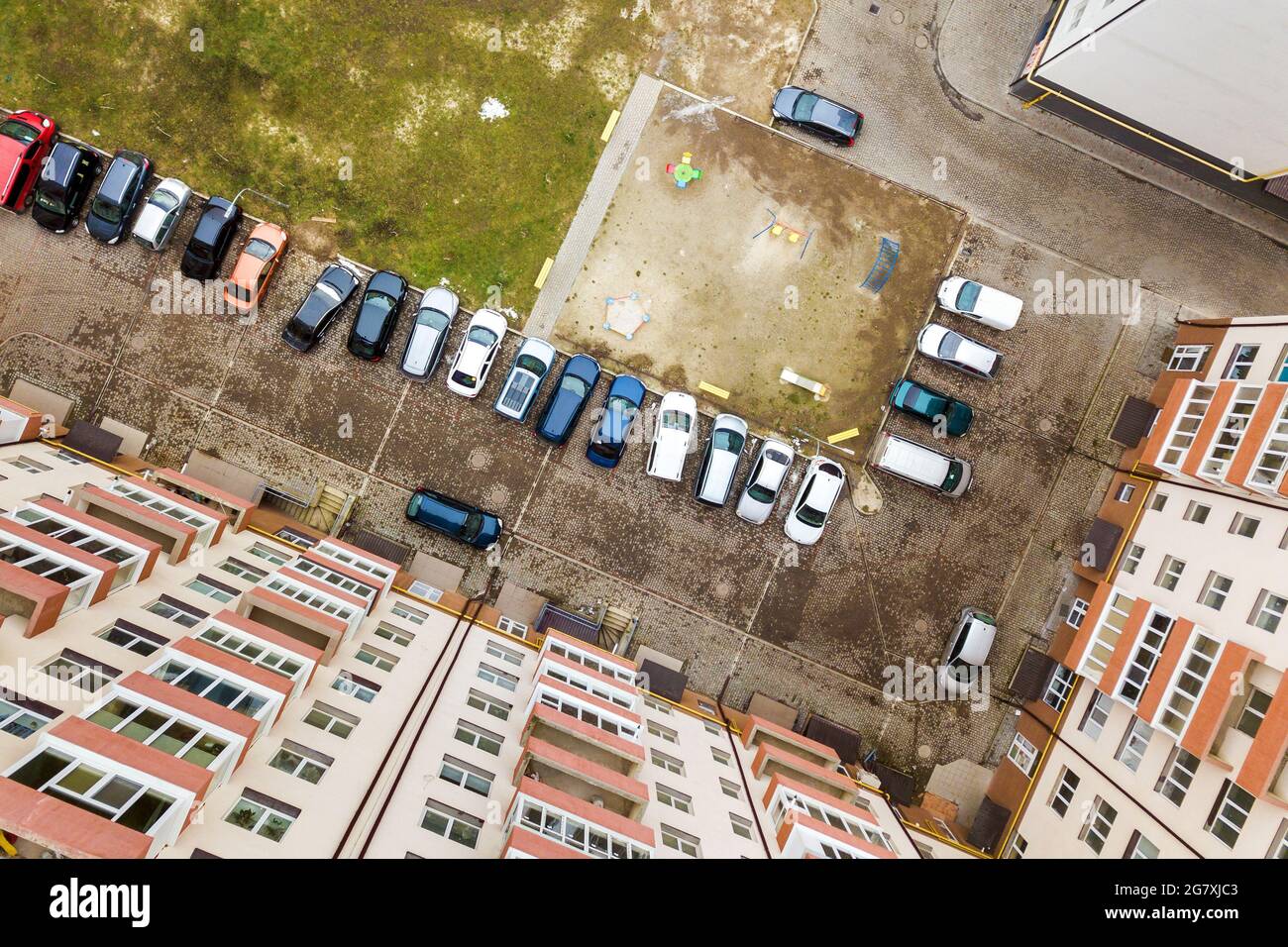 Aerial view of parked cars on parking lot between high apartment ...