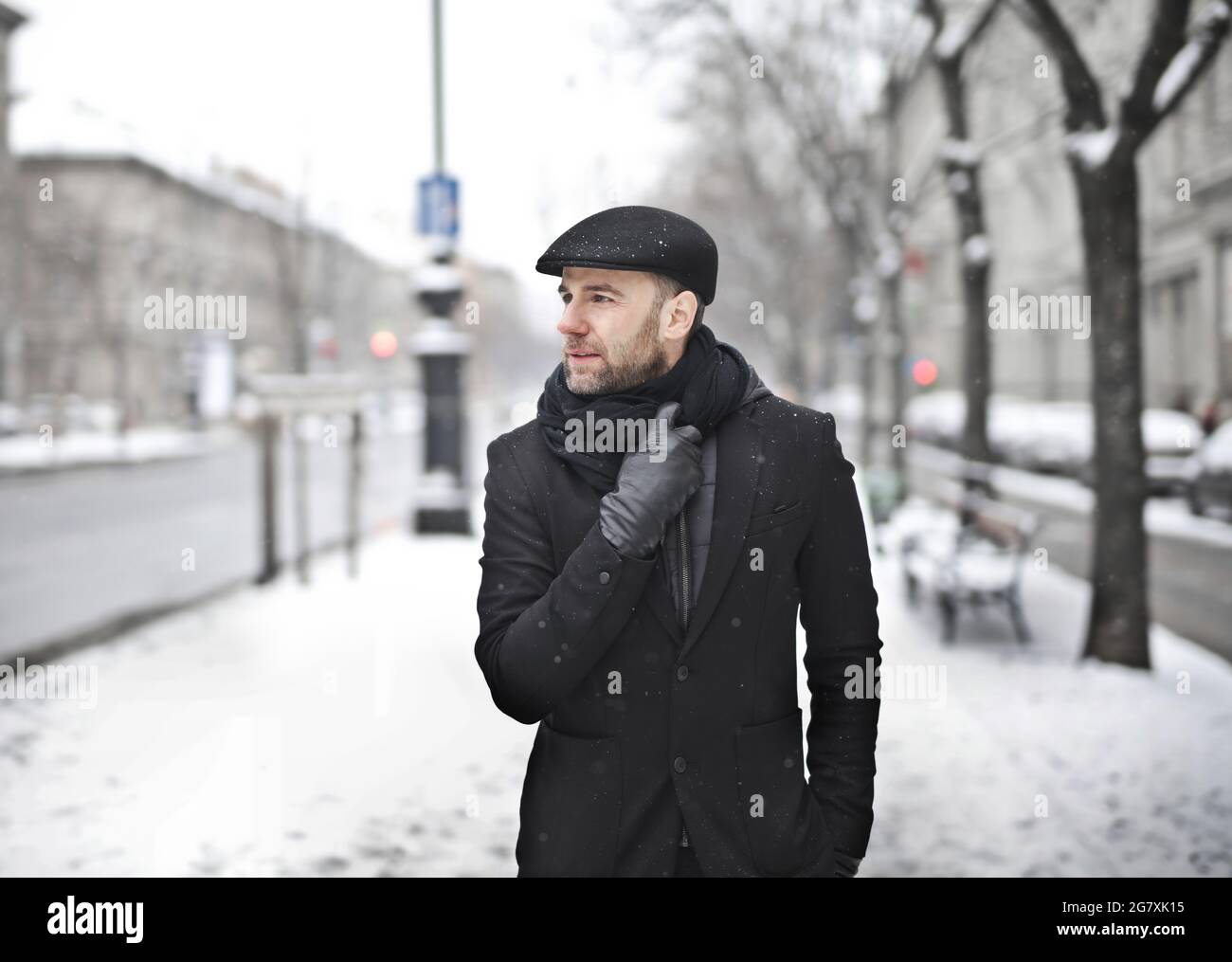 Shallow focus of a Caucasian man wearing a winter coat with gloves and ...