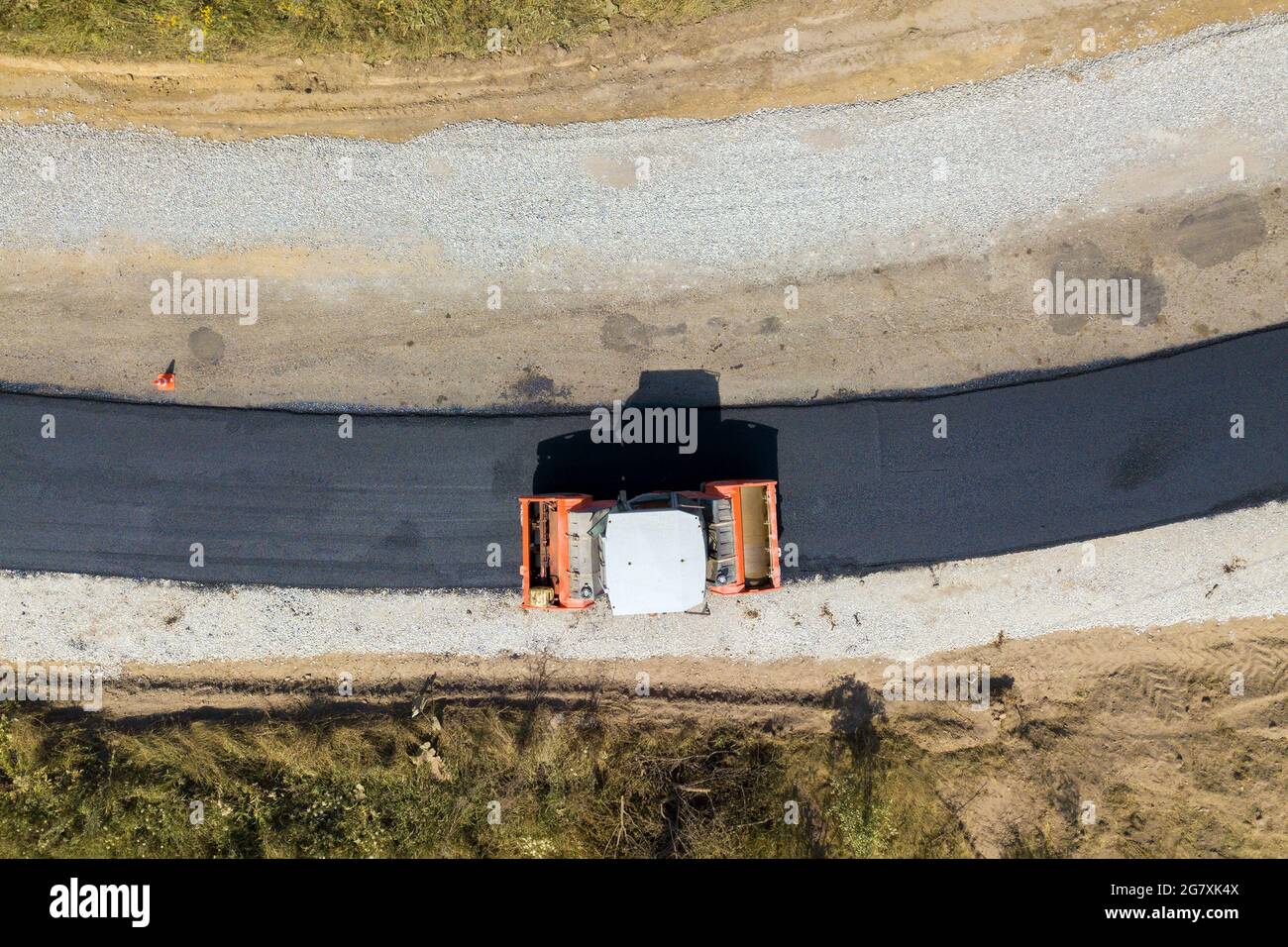 Aerial view of new road construction with steam roller machine at work ...