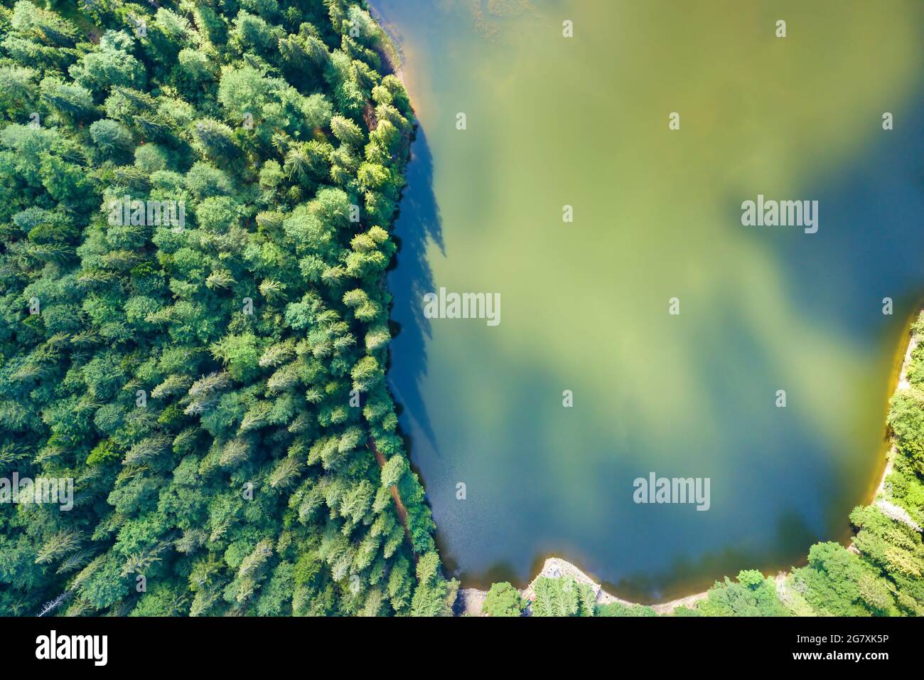 Top down aerial view of big lake with clear blue water between high ...