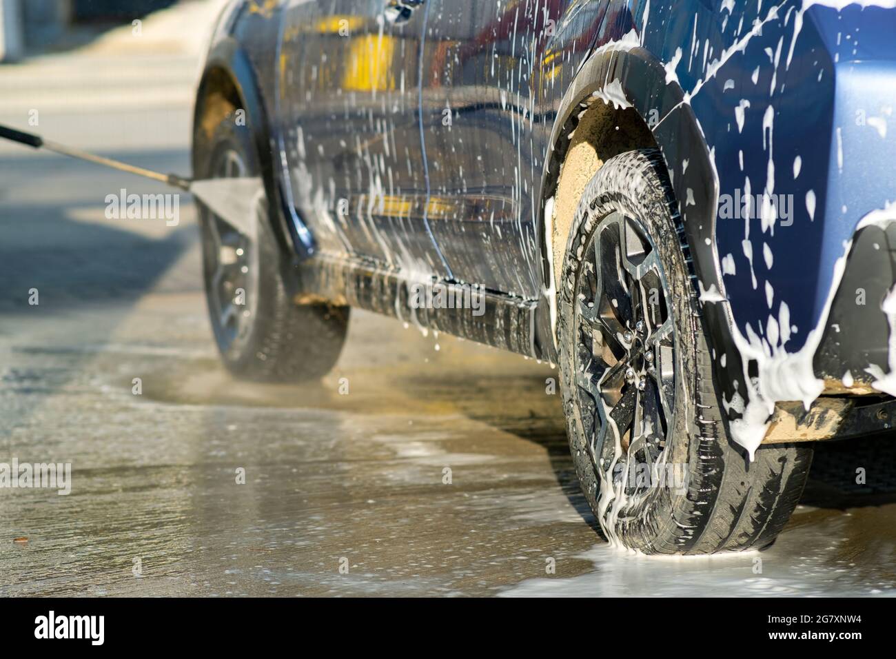 Closeup of male driver washing his car with contactless high pressure ...