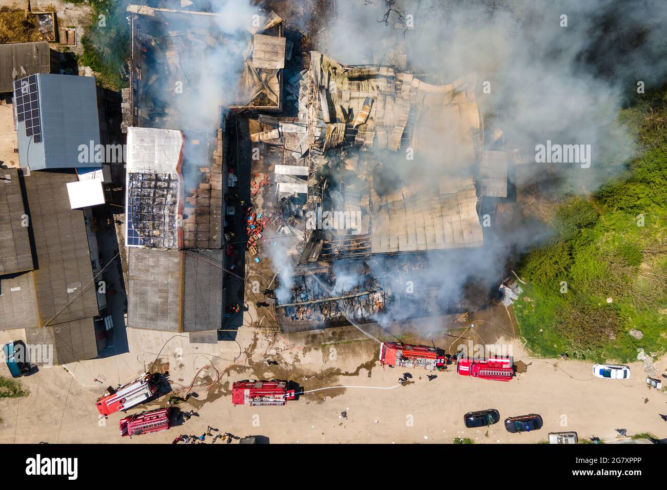 Aerial view of firefighters extinguishing ruined building on fire with ...