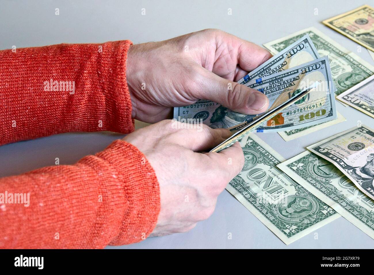 Caucasian man's hands counting dollar banknotes on gray surface. Male ...