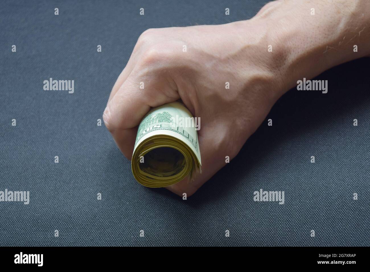Bundle of rolled up dollar bills clutched in caucasian man's hand. Male ...
