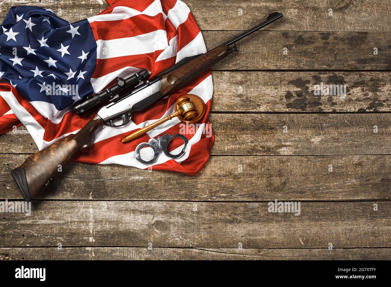 Wooden judge gavel and hunting rifle over USA flag on wooden background ...