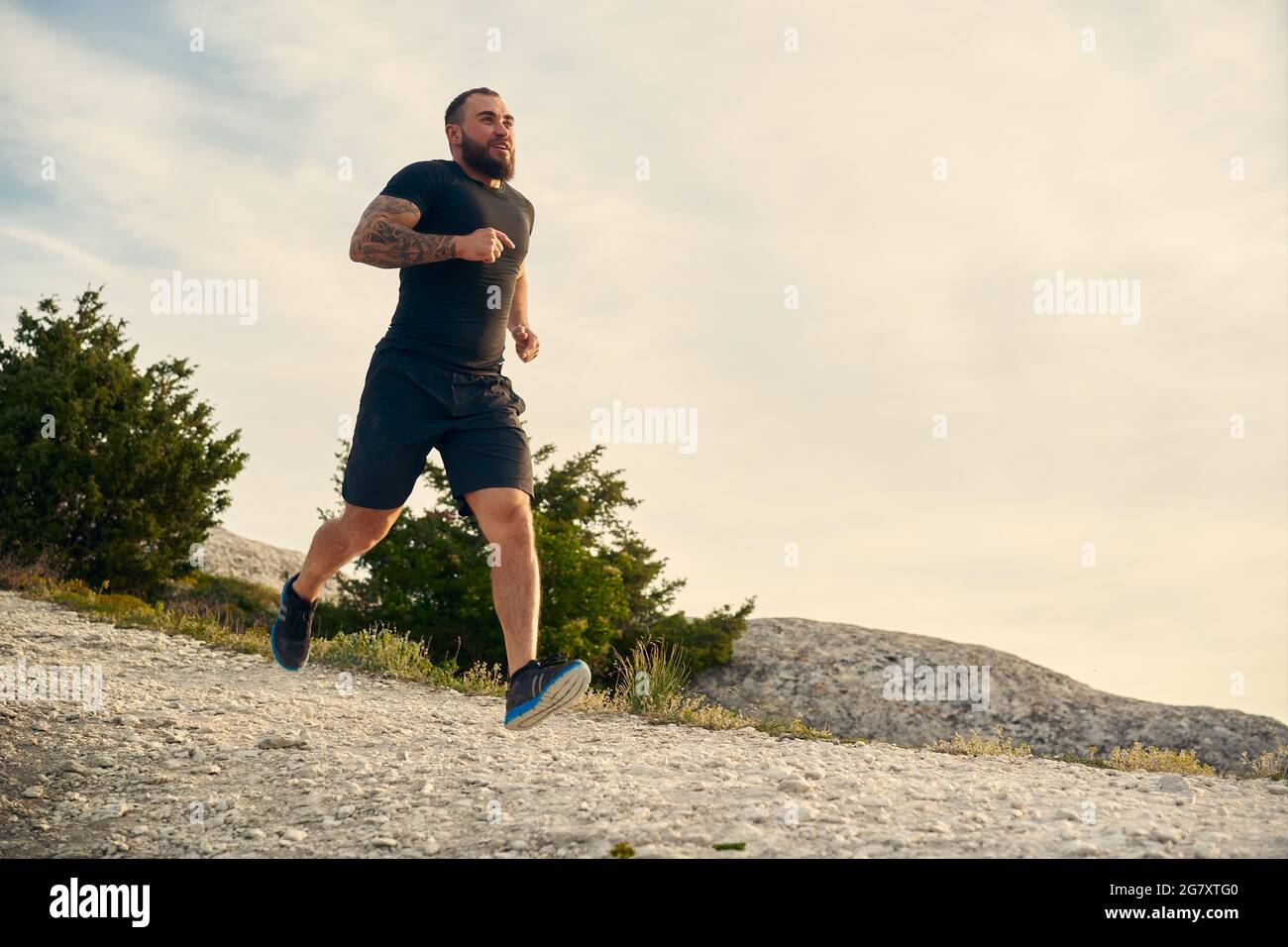 Young muscular male athlete running up the hill Stock Photo - Alamy