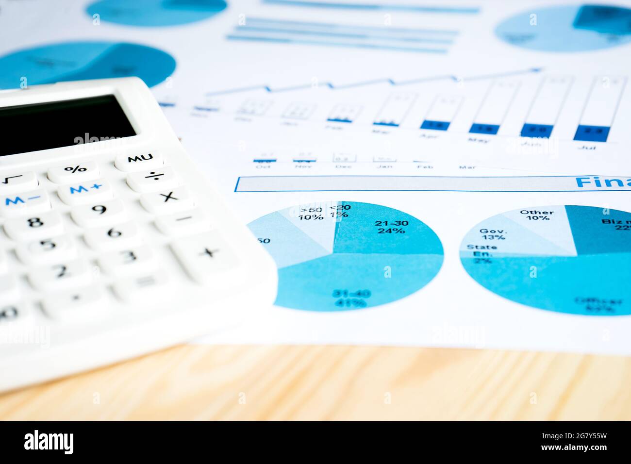 Blue graphs on white paper with calculator Stock Photo - Alamy