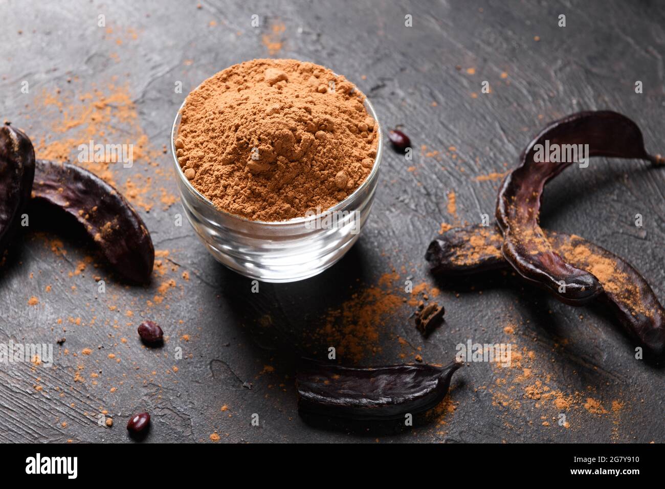 Dry carob pods and carob powder over dark background Stock Photo - Alamy