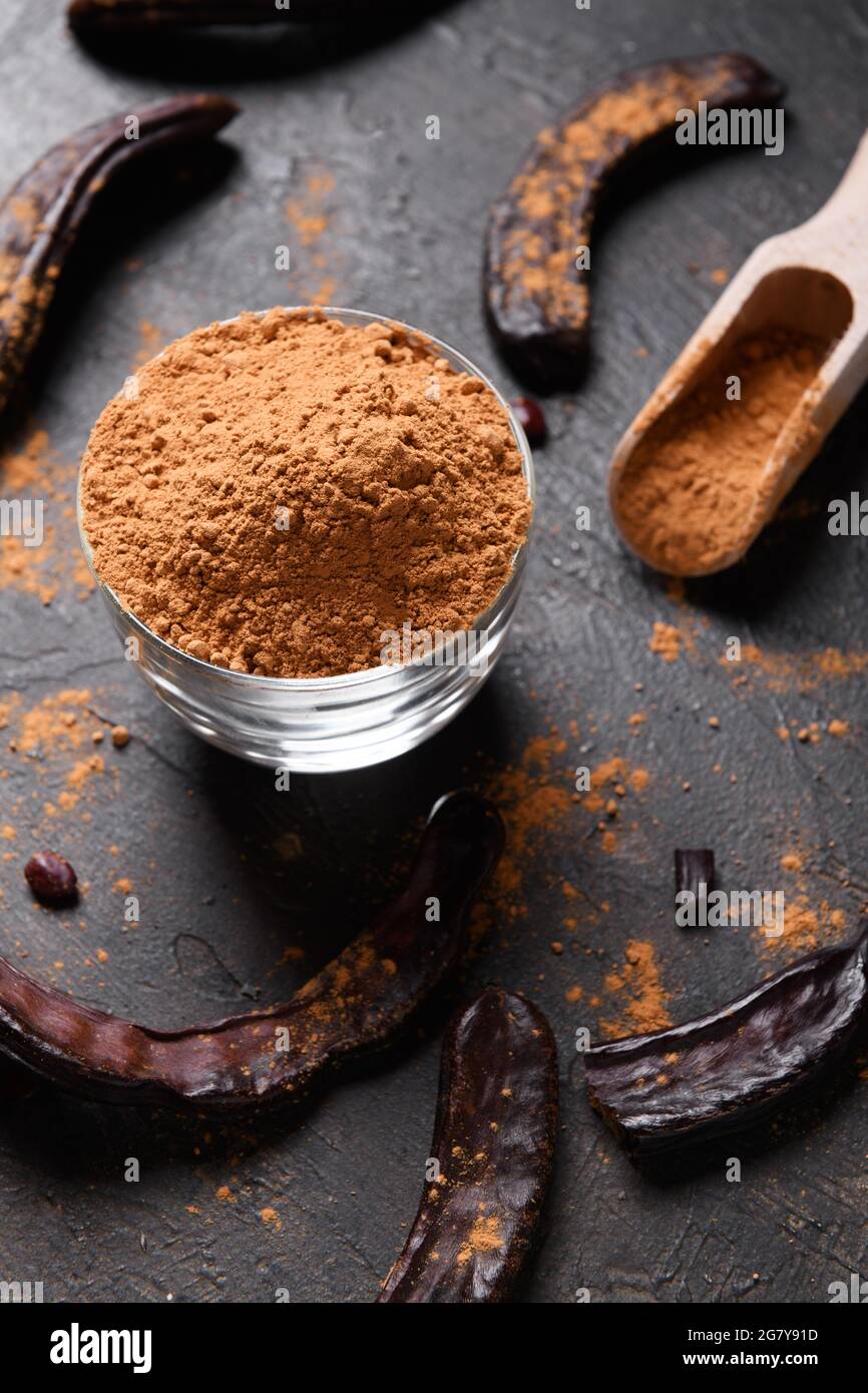 Dry carob pods and carob powder over dark background Stock Photo - Alamy