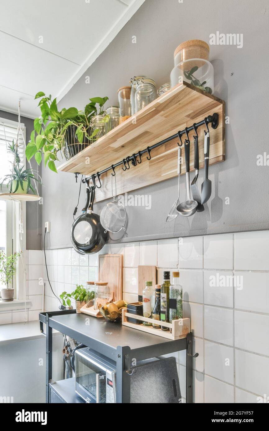 Vertical shot of a wooden rack over the table with oven in a tiled ...