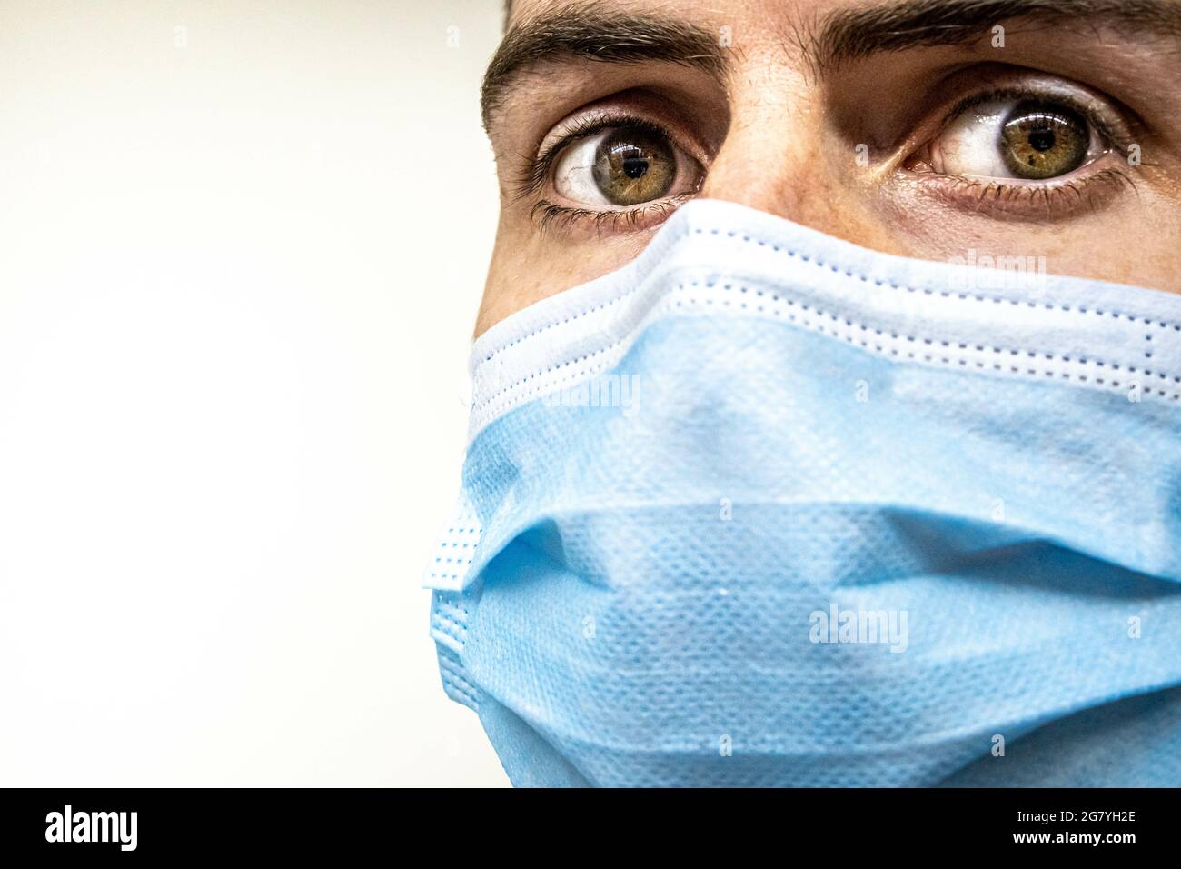Portrait of a young blond man from Argentina in a surgical ace mask ...