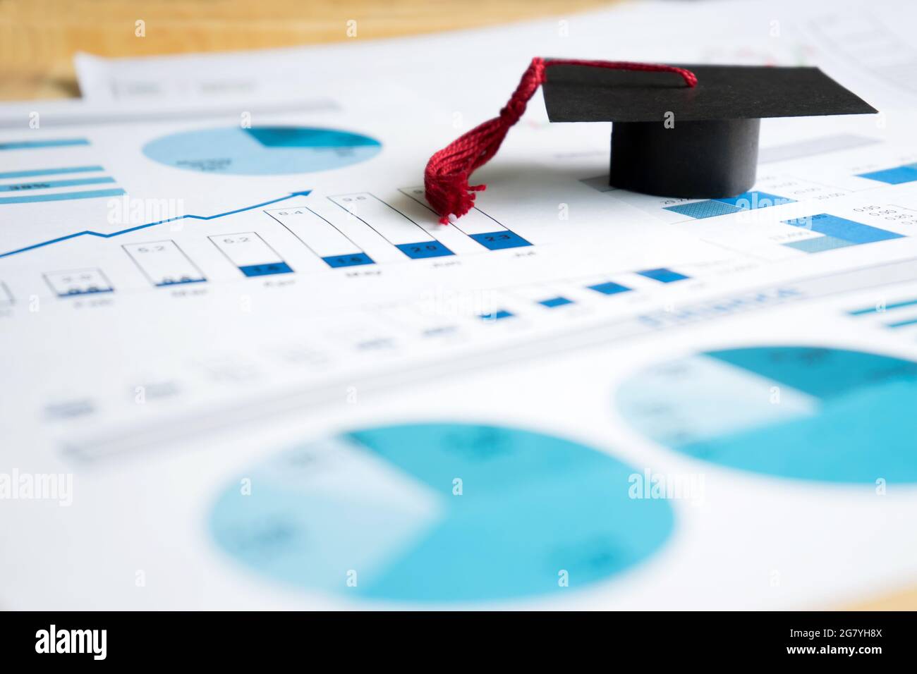 graduation caps on blue graphs and charts printed Stock Photo - Alamy
