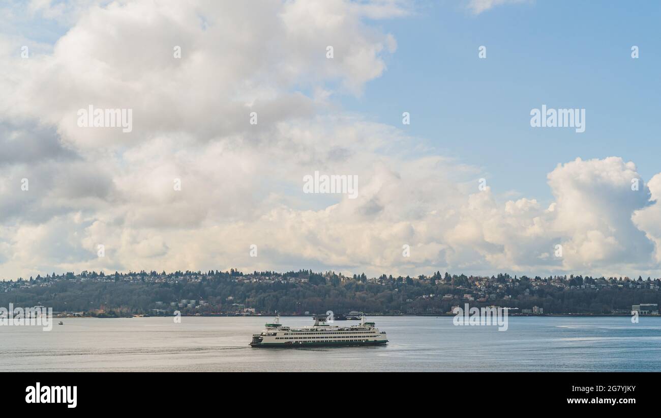 Washington Ferry sails on Elliot Bay with West Seattle and Cloud sky ...