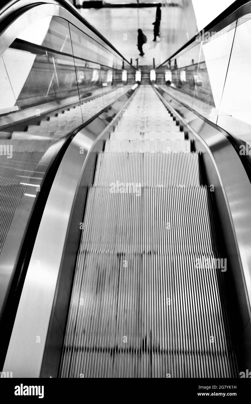 Escalator in office building with three people, strong perspective ...
