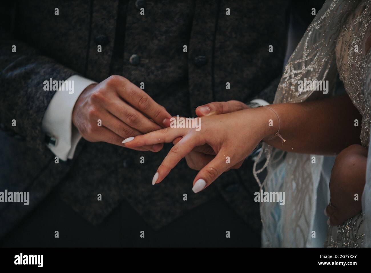 Groom putting the ring on the bride during the wedding ceremony at the ...
