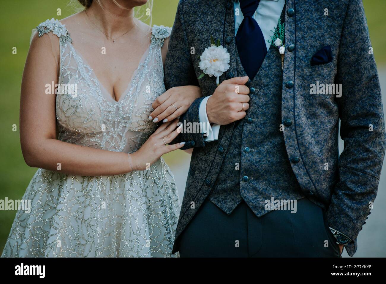 Bride holding the groom's arm in the park during the wedding ceremony ...
