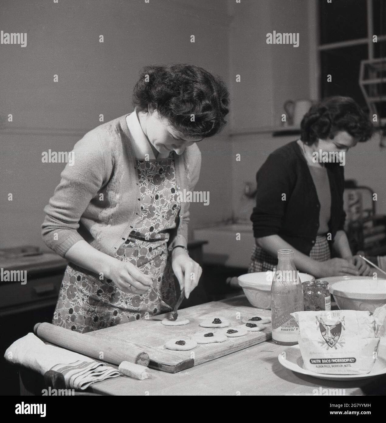 1950s, historical, at a cookery class, two women at making pastries ...