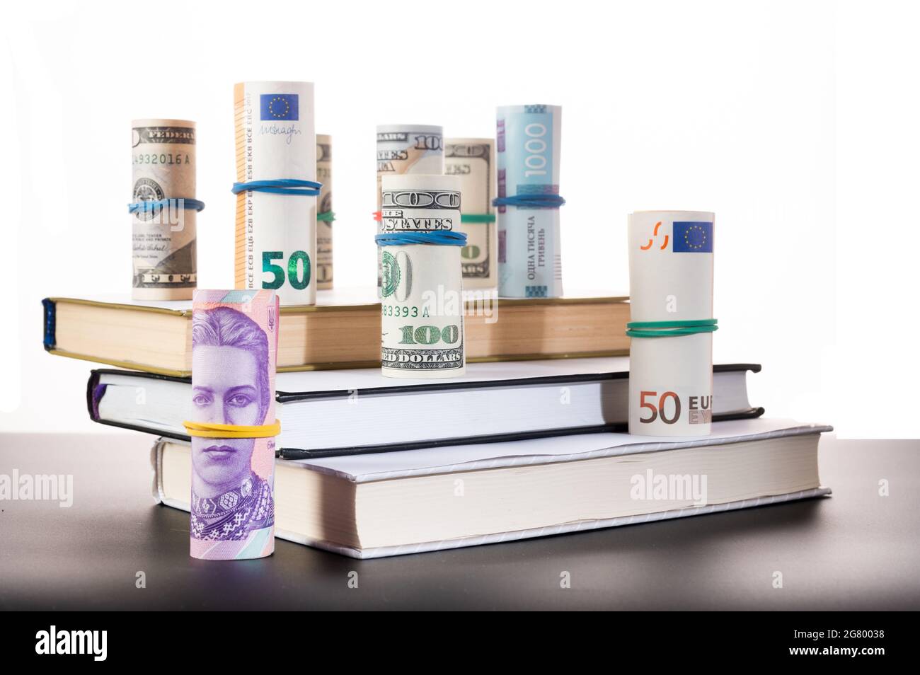 Diverse currency on the steps. Hierarchy of money. Money and books ...