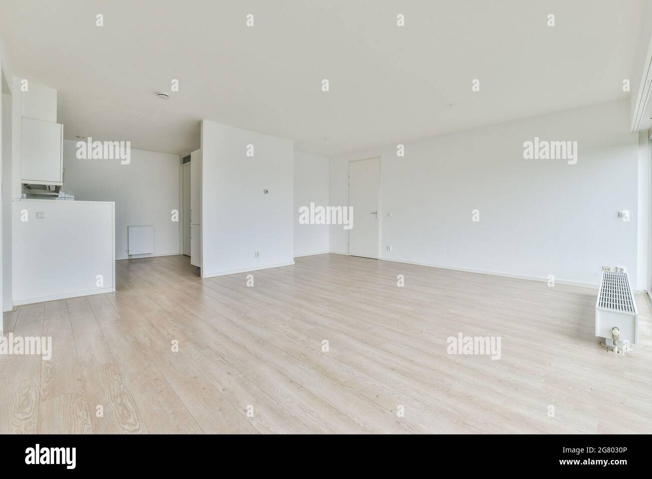 Empty white large room with laminate flooring Stock Photo - Alamy