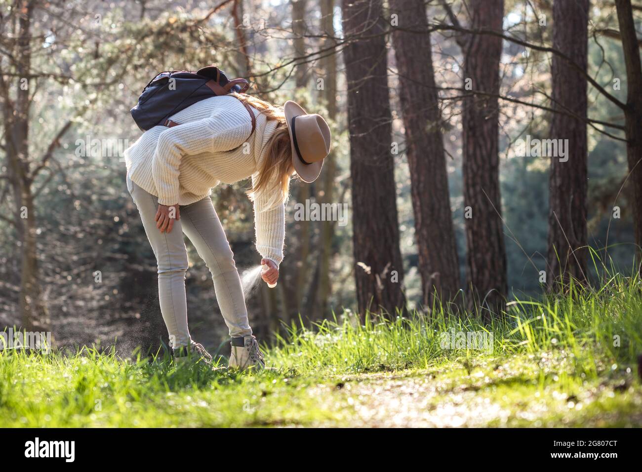 Woman spraying insect repellent against tick at her legs. Protection ...