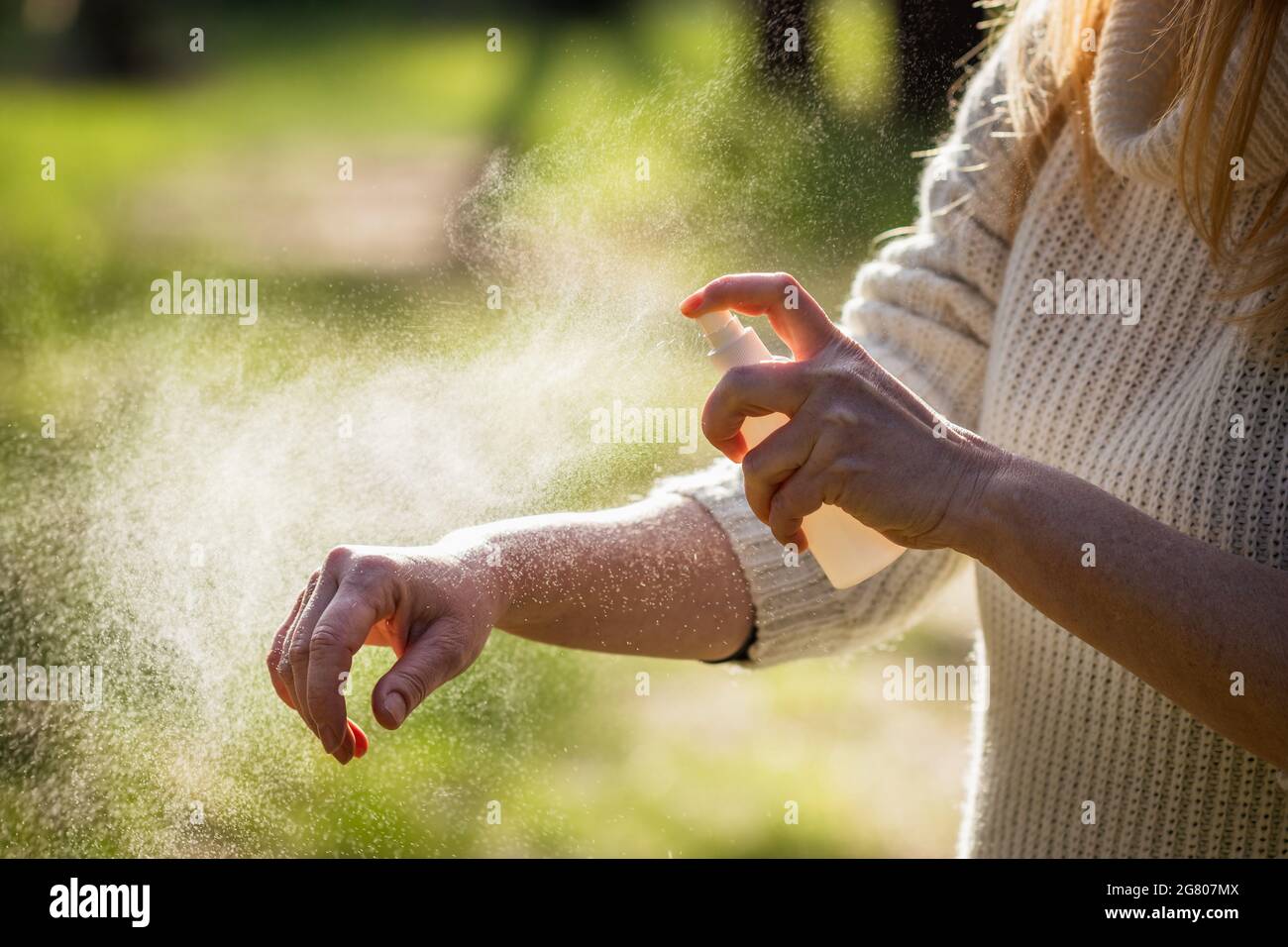 Insect repellent. Woman tourist applying mosquito repellent on hand ...