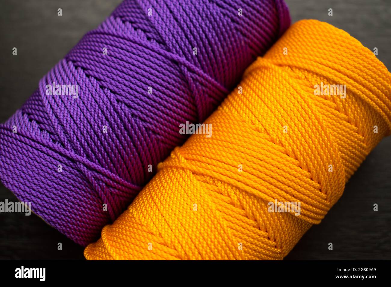 Close up of some different colorful rolls of thread on a black wooden ...