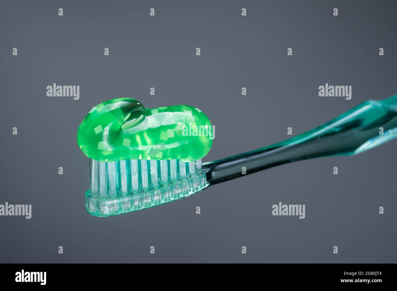 Green toothpaste. Toothpaste on a toothbrush. Toothpaste with additives ...
