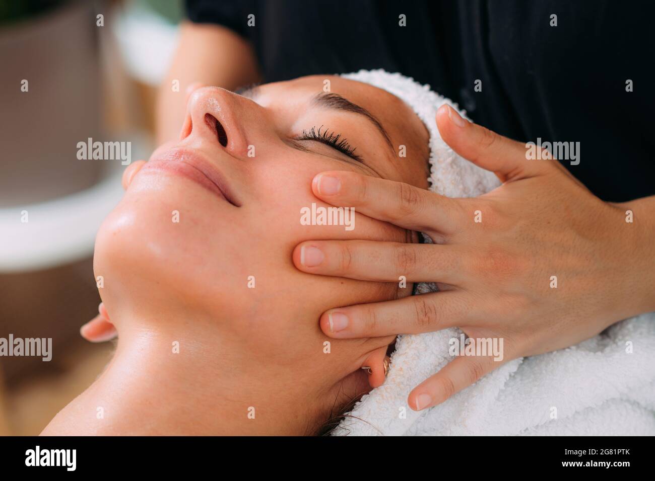 Ayurveda therapist massaging female client face Stock Photo - Alamy