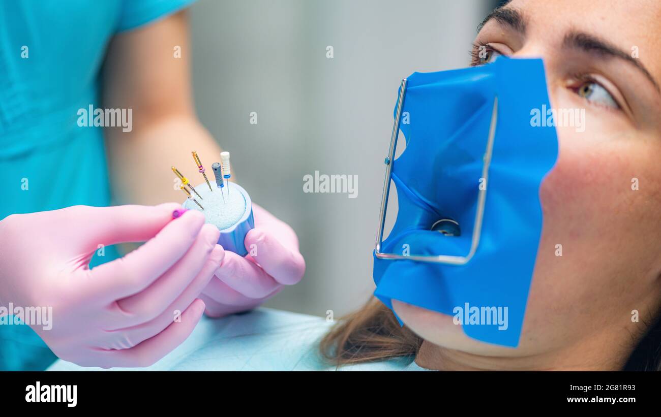 Endodontist setting barbed broach for endodontic treatment Stock Photo ...