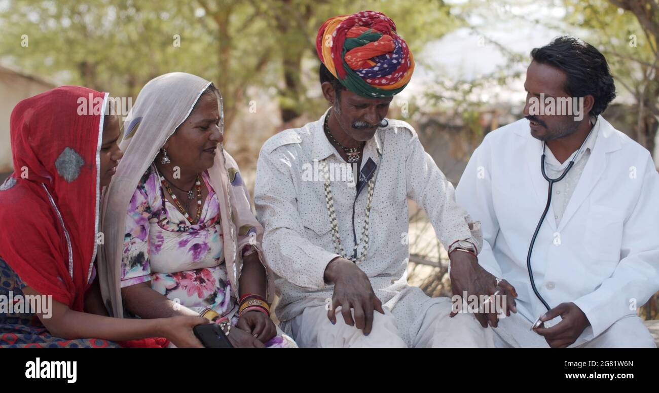 Group of South Asian people in traditional Indian clothing having a ...