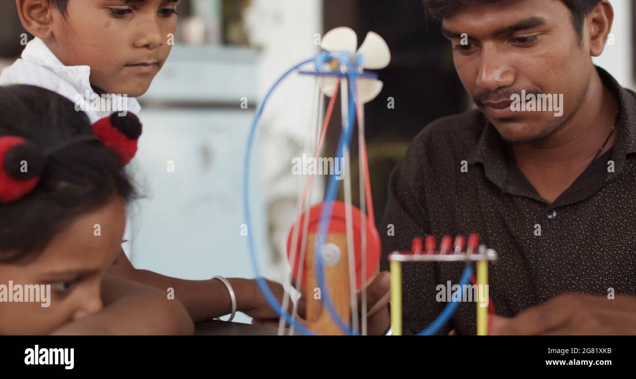 Male South Asian teacher showing children educational toys Stock Photo ...