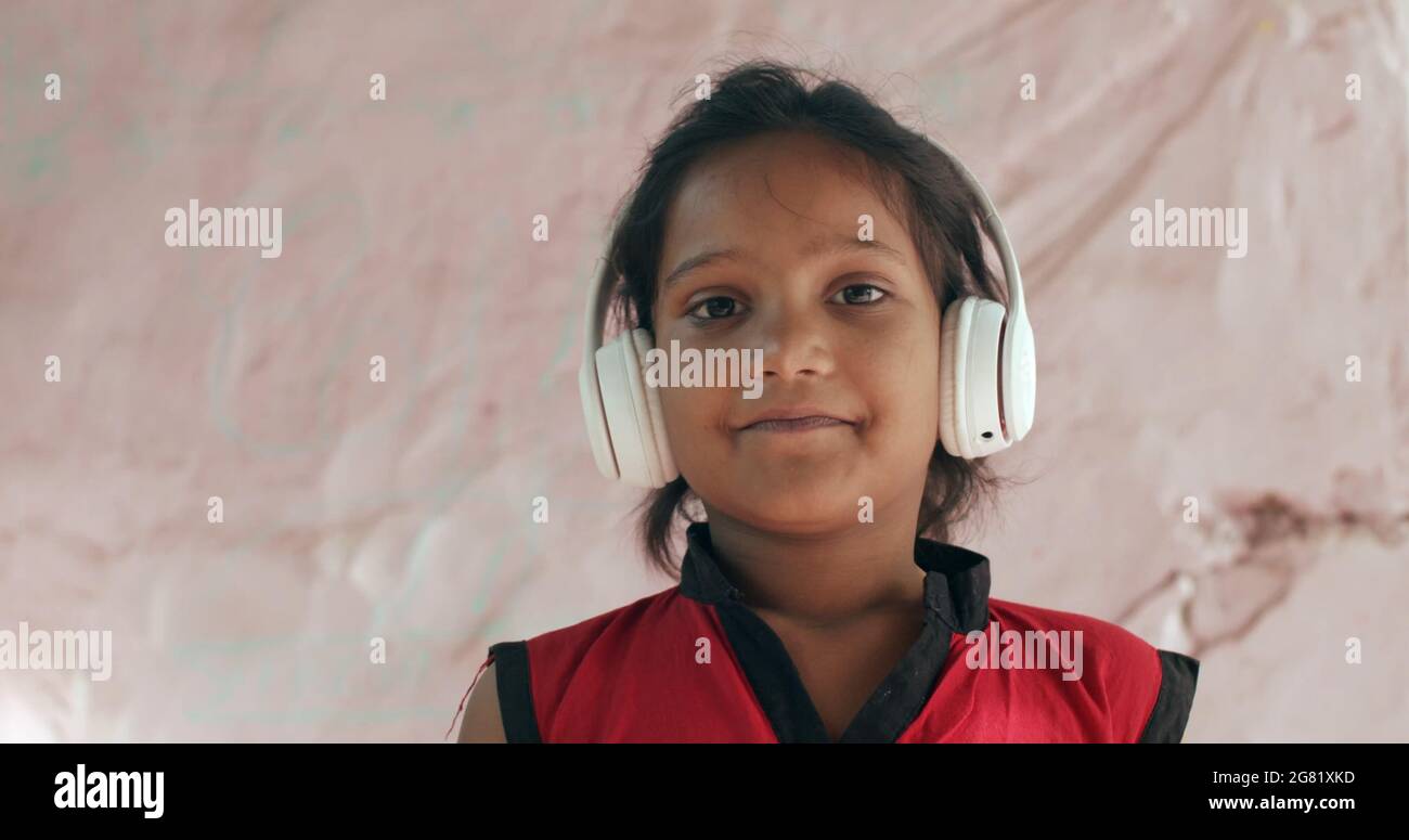 South Asian female child listening to music with headphones Stock Photo ...
