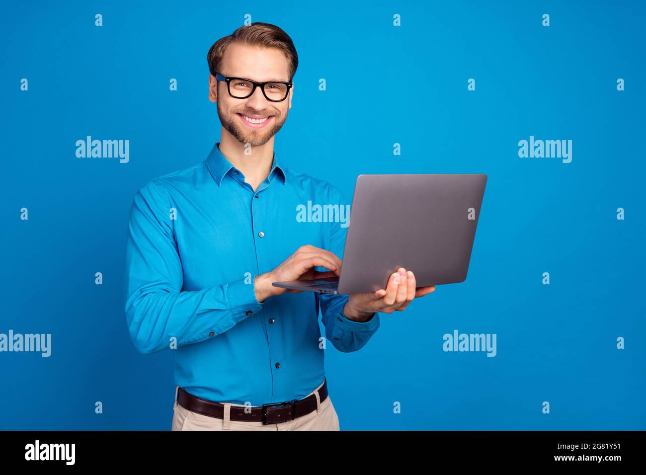 Photo of young business man happy positive smile programmer work project isolated over blue ...