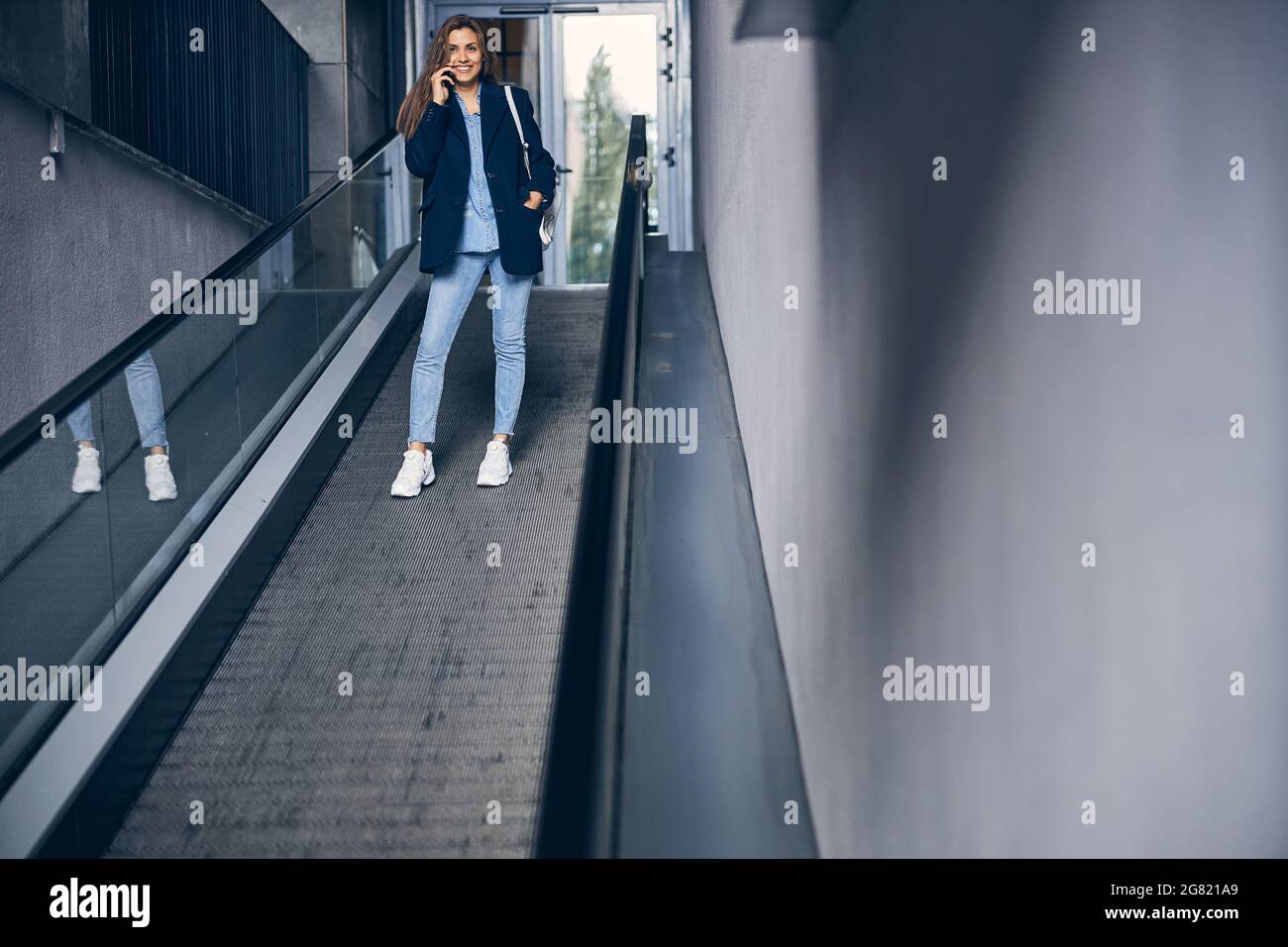 Pretty brunette female looking happy going down Stock Photo - Alamy