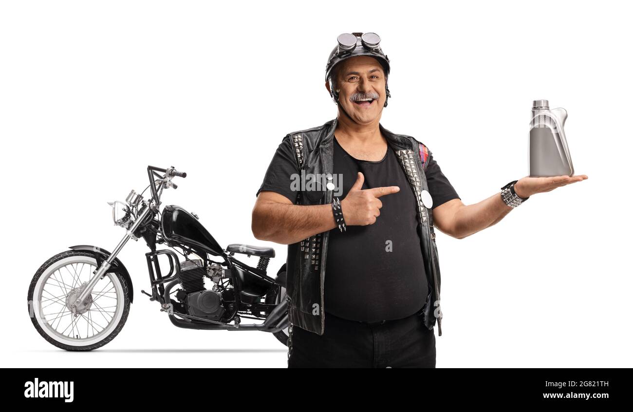 Mature man biker with a chopper holding an engine oil and pointing ...