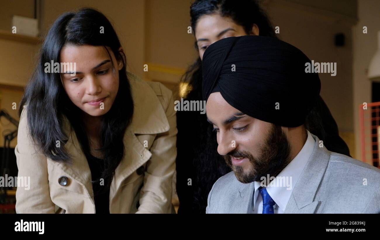 South Asian office workers with their boss laughing sarcastically ...