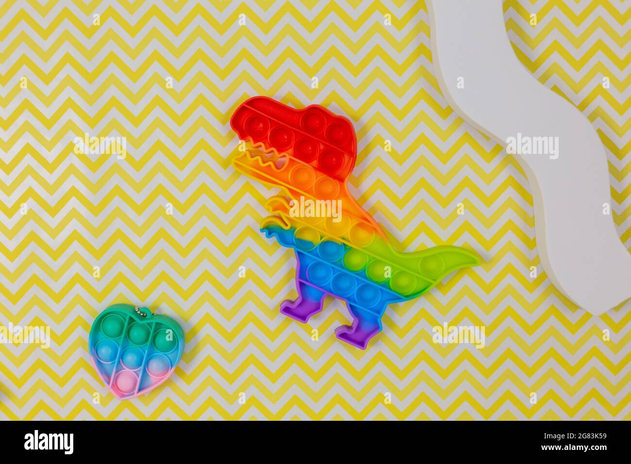 Popular silicone anti-stress pop-it toys for a child on the yellow ...