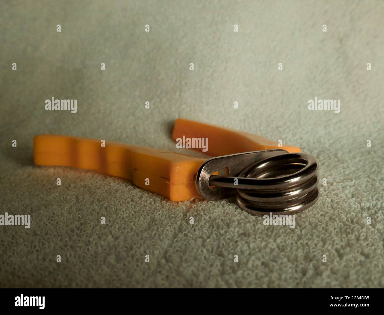 Hand finger gym tool presenting in yellow color at white backdrop ...