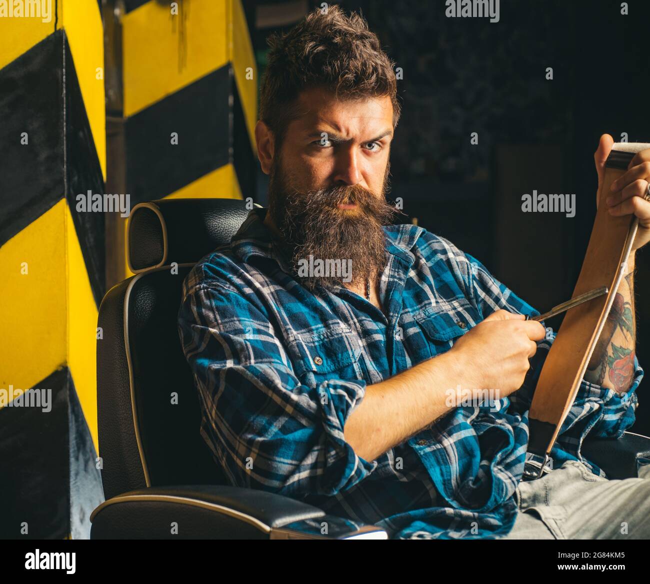 Beard man sharpens the razor in barber shop. Razor sharp. Shaving man ...