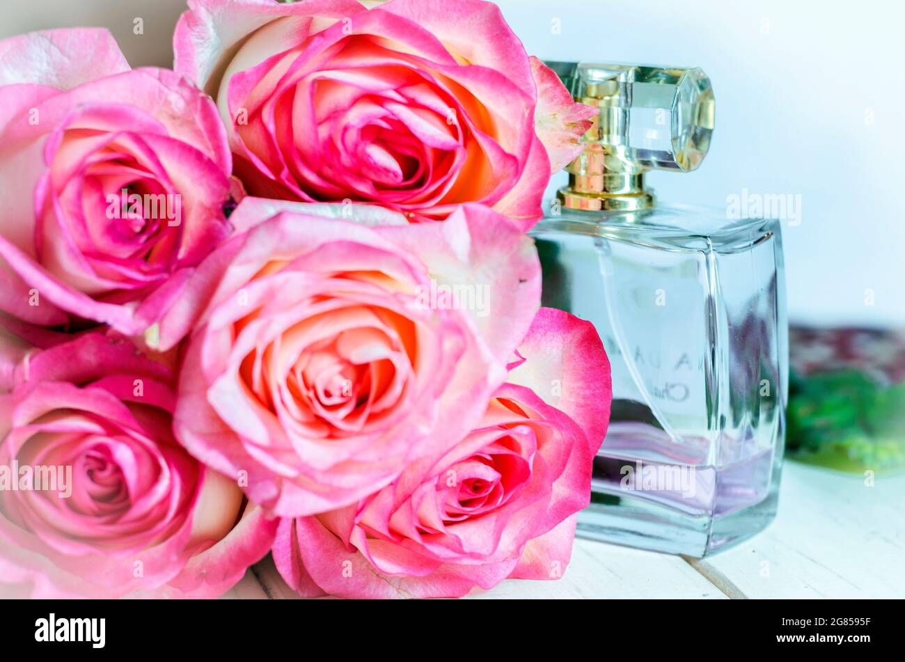 a bottle of perfume among beautiful flowers Stock Photo - Alamy