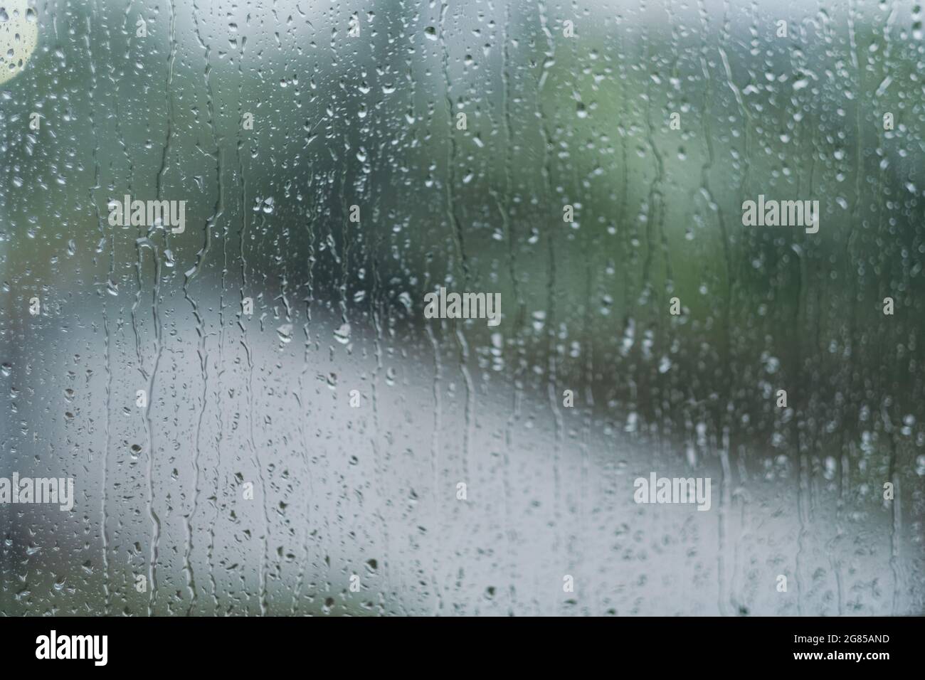 raindrops during raining in the rainy day outside window glass with a ...