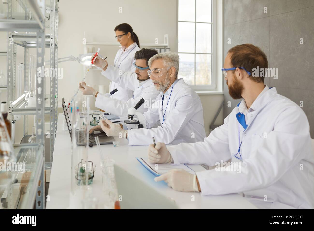 Group of scientists doing advanced scientific research in modern ...