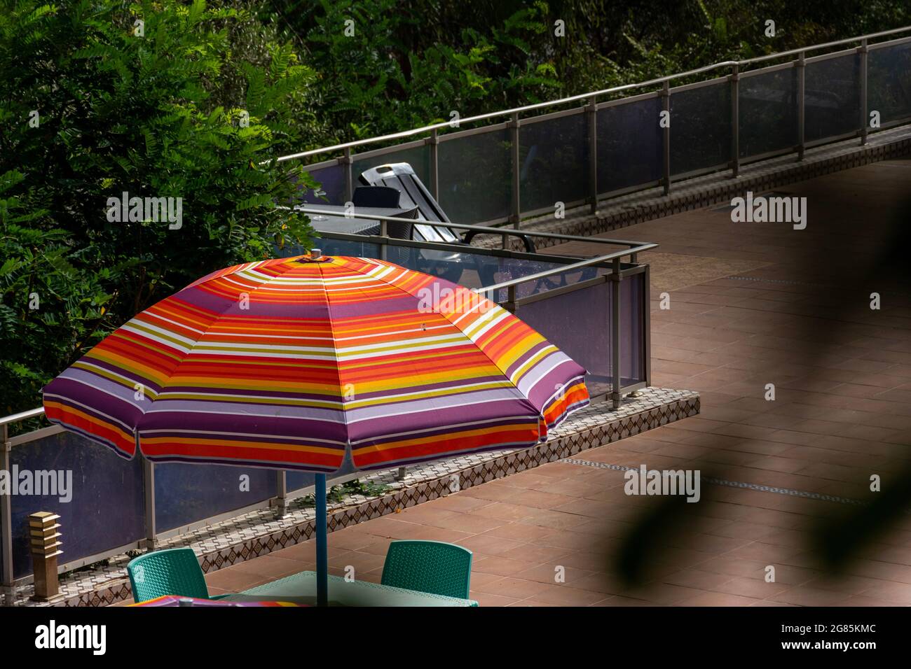 Colorful parasol with plastic chairs Stock Photo - Alamy