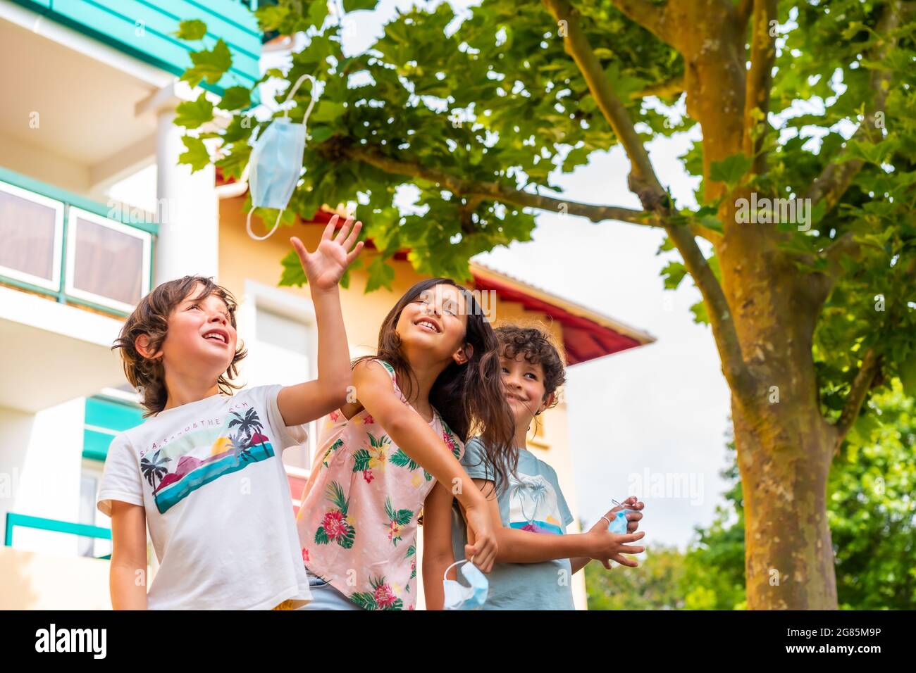 Low angle shot of three Caucasian children pulling up their surgical ...
